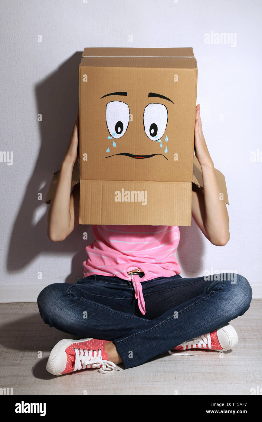 Woman with cardboard box on her head with sad face, near wall Stock ...