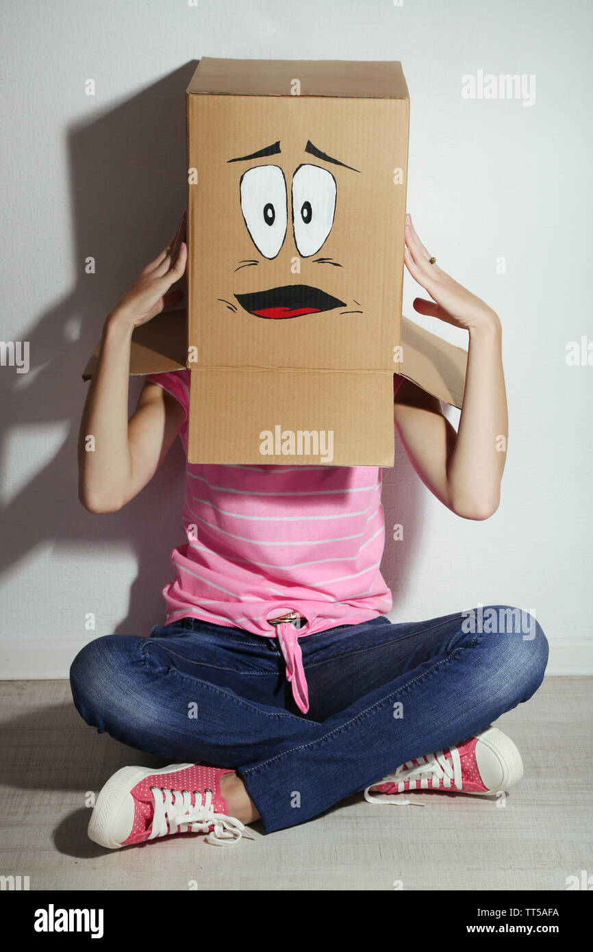 Woman with cardboard box on her head with sad face, near wall Stock ...