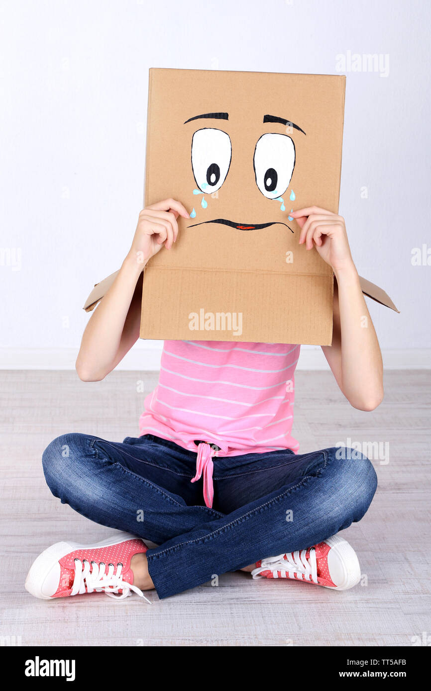 Woman with cardboard box on her head with sad face, near wall Stock ...