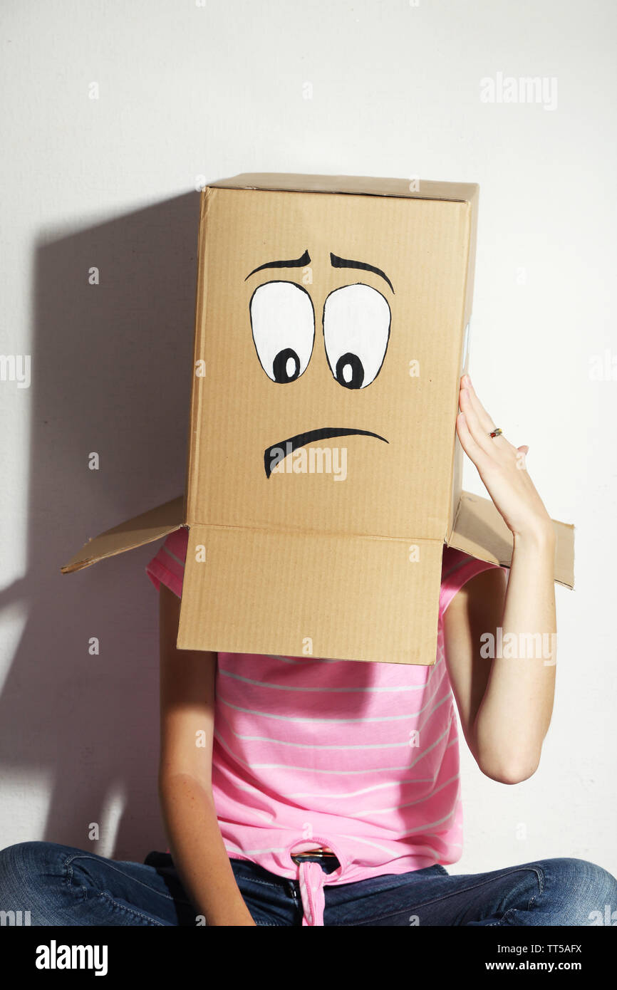 Woman with cardboard box on her head with sad face, near wall Stock ...