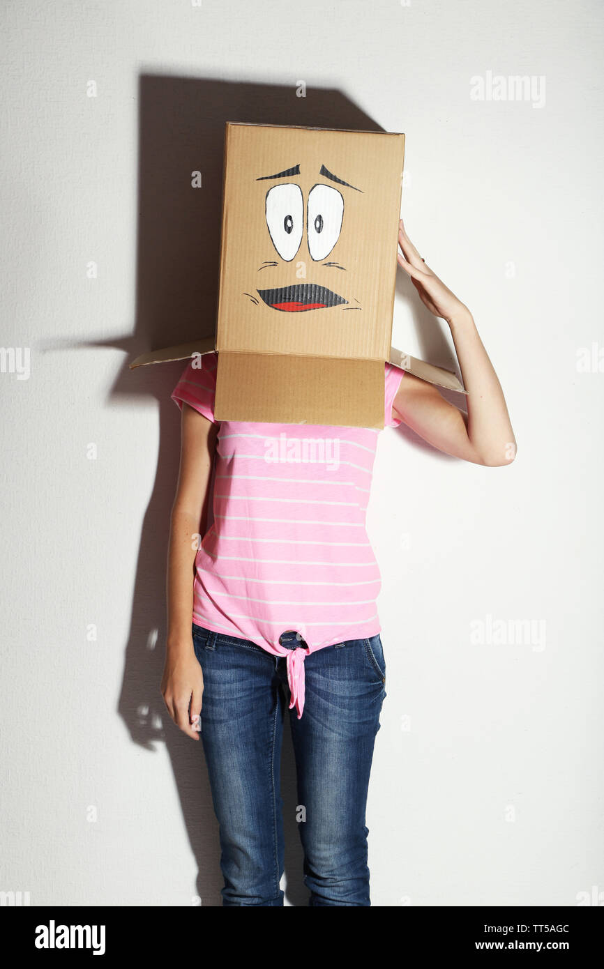 Woman with cardboard box on her head with sad face, near wall Stock ...