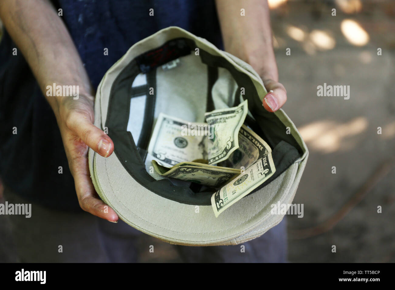 Homeless beggar money on his hat Stock Photo - Alamy