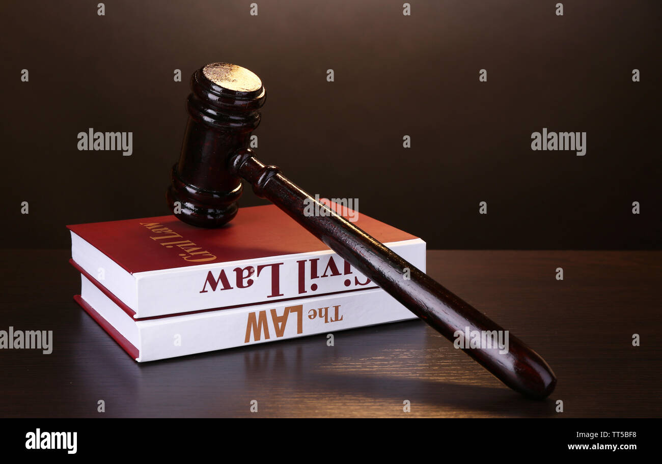 Books of Law and hammer on table on brown background Stock Photo - Alamy