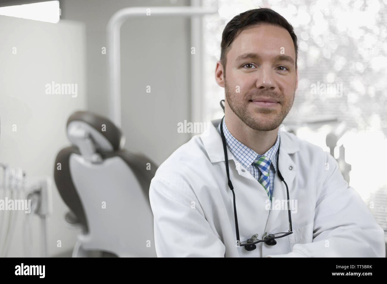 Closeup portrait of friendly dentist in a modern clinic, sitting Stock ...