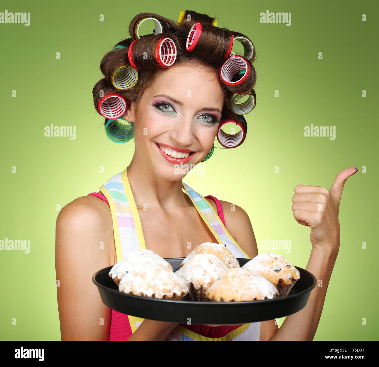 Beautiful girl in hair curlers on green background Stock Photo - Alamy