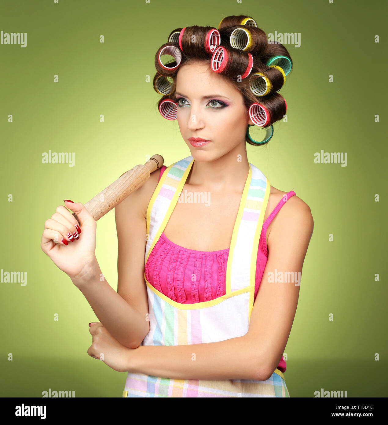 Beautiful girl in hair curlers on green background Stock Photo - Alamy