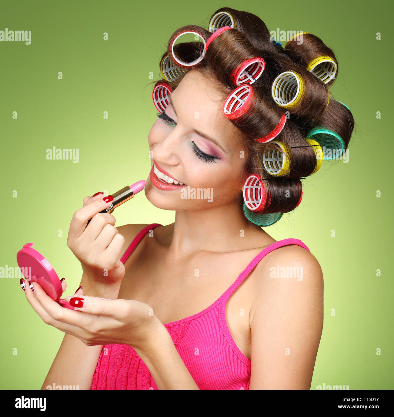 Beautiful girl in hair curlers on green background Stock Photo - Alamy