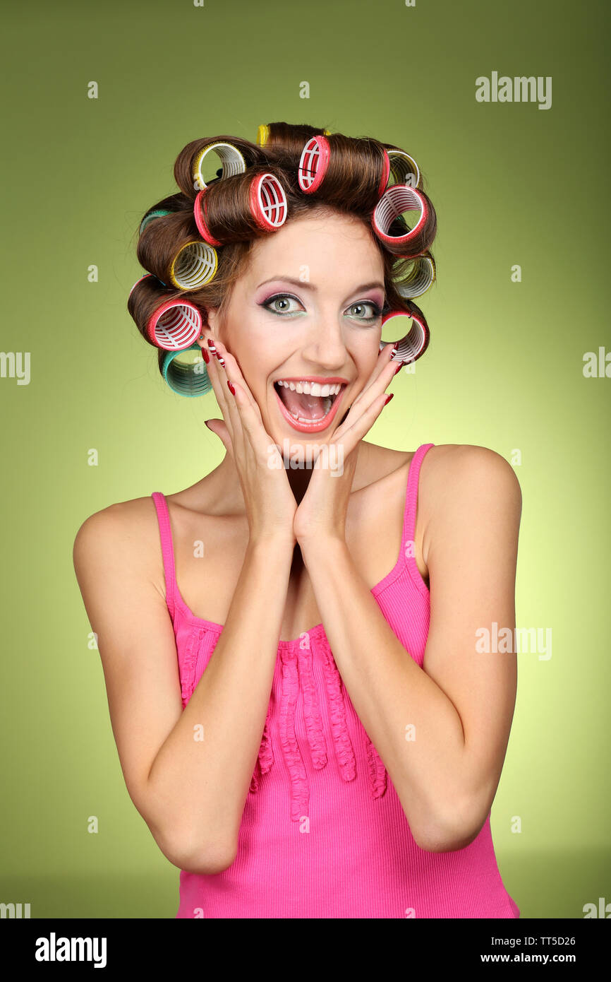 Beautiful girl in hair curlers on green background Stock Photo - Alamy