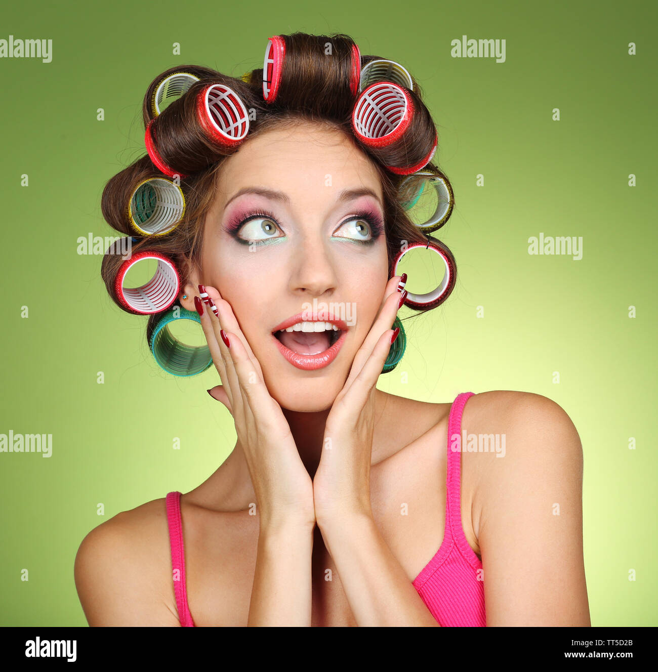 Beautiful girl in hair curlers on green background Stock Photo - Alamy