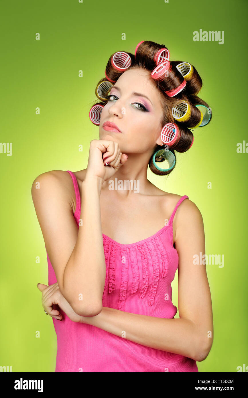 Beautiful girl in hair curlers on green background Stock Photo - Alamy