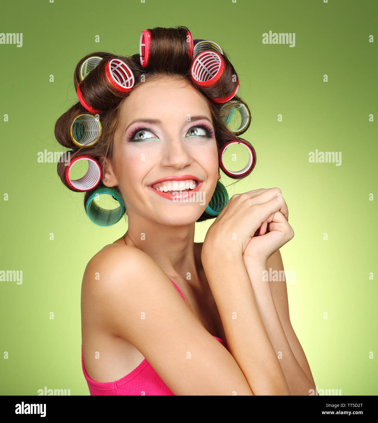 Beautiful girl in hair curlers on green background Stock Photo - Alamy