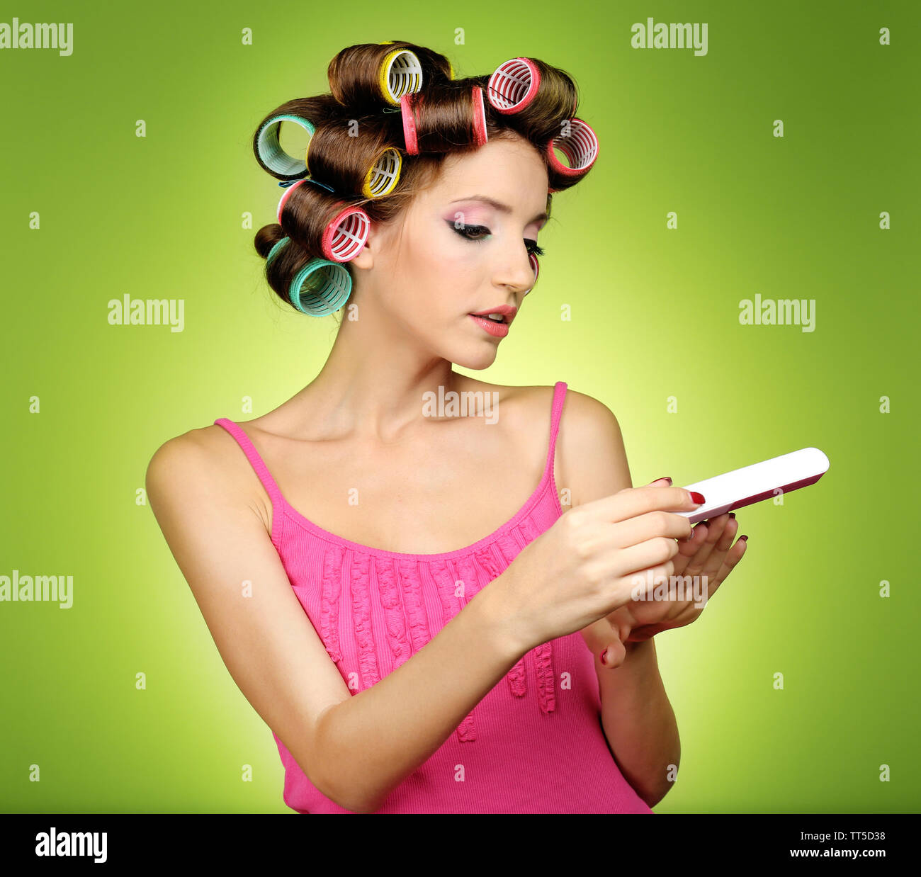 Beautiful girl in hair curlers on green background Stock Photo - Alamy