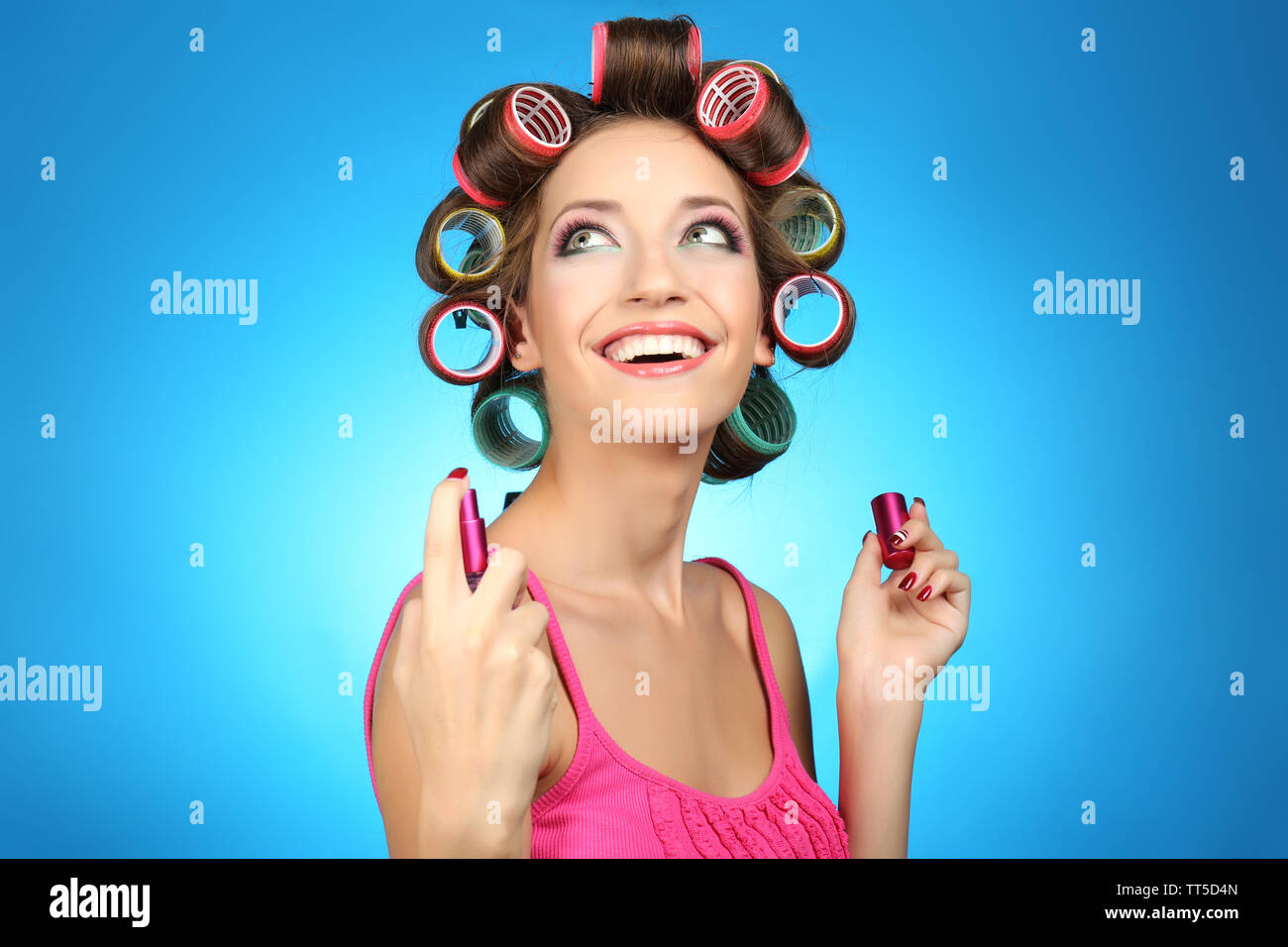 Beautiful girl in hair curlers on blue background Stock Photo - Alamy