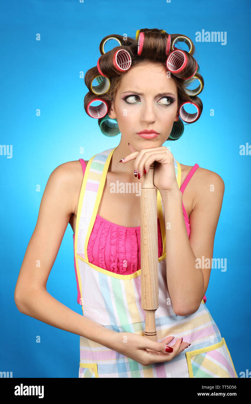 Beautiful girl in hair curlers on blue background Stock Photo - Alamy