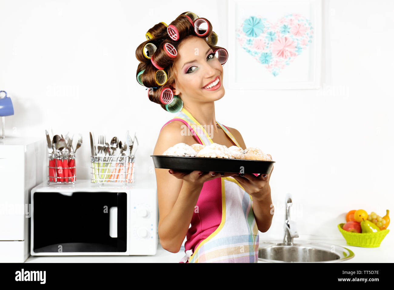 Beautiful girl in hair curlers in kitchen Stock Photo - Alamy