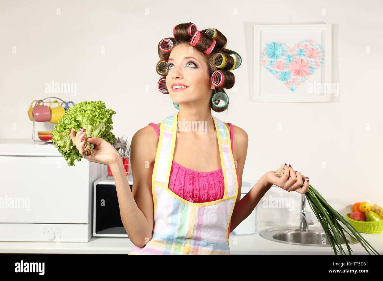 Beautiful girl in hair curlers in kitchen Stock Photo - Alamy