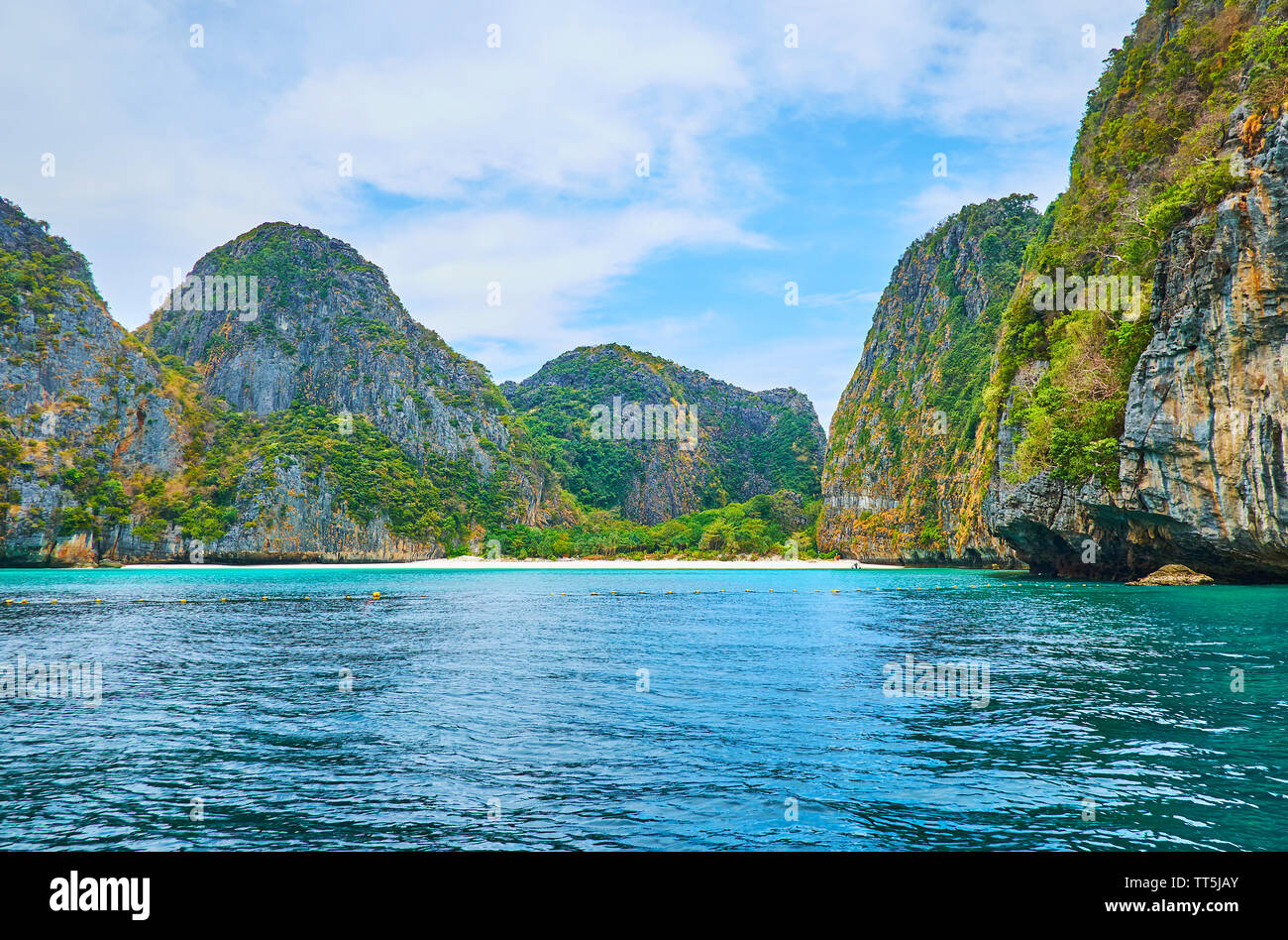 The white sand beach of Maya Bay, surrounded by tropical greenery and rocks of Phi Phi Leh ...