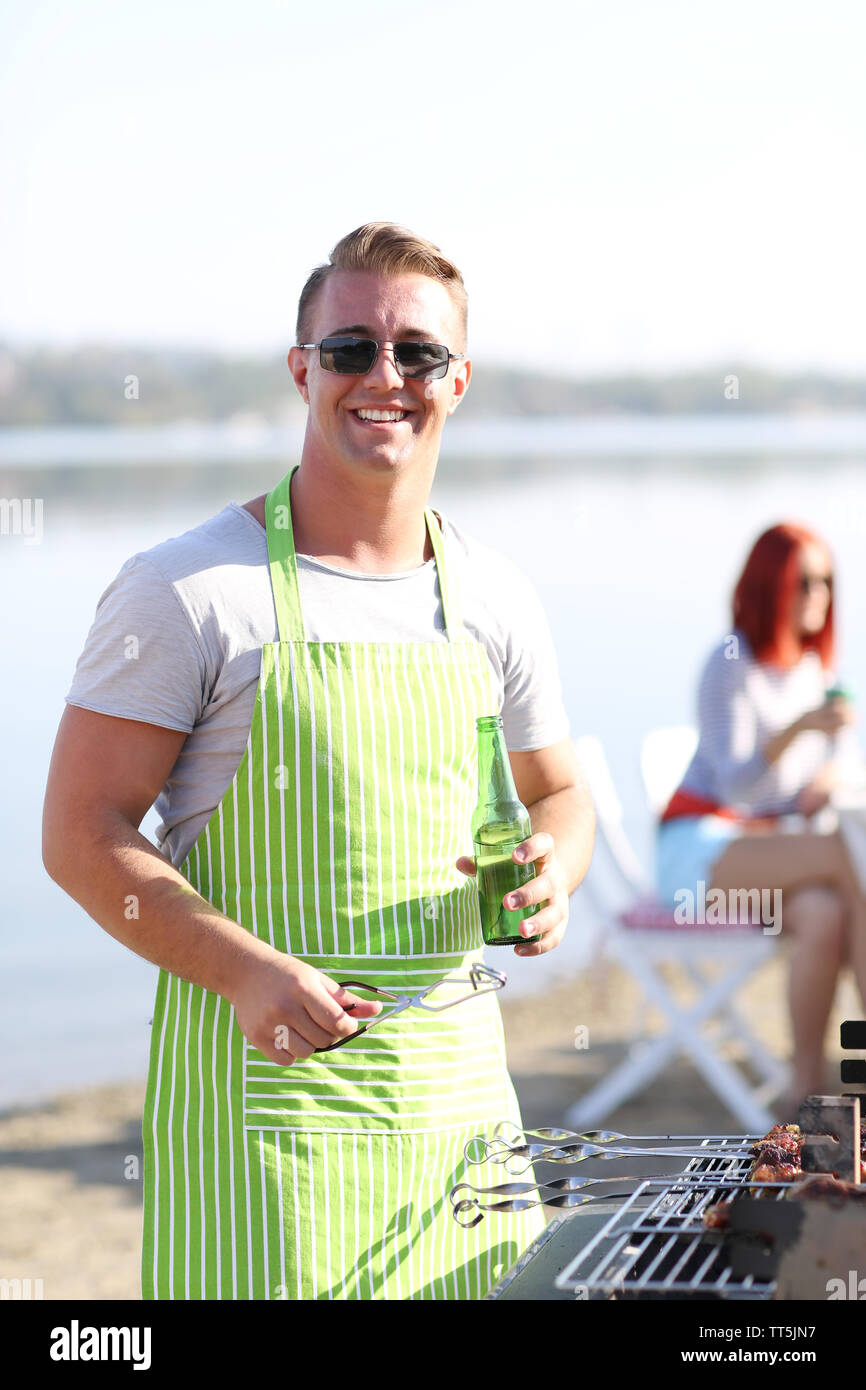 Young man cooking on barbecue, outdoors Stock Photo - Alamy