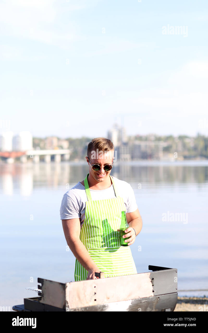 Young man cooking on barbecue, outdoors Stock Photo - Alamy