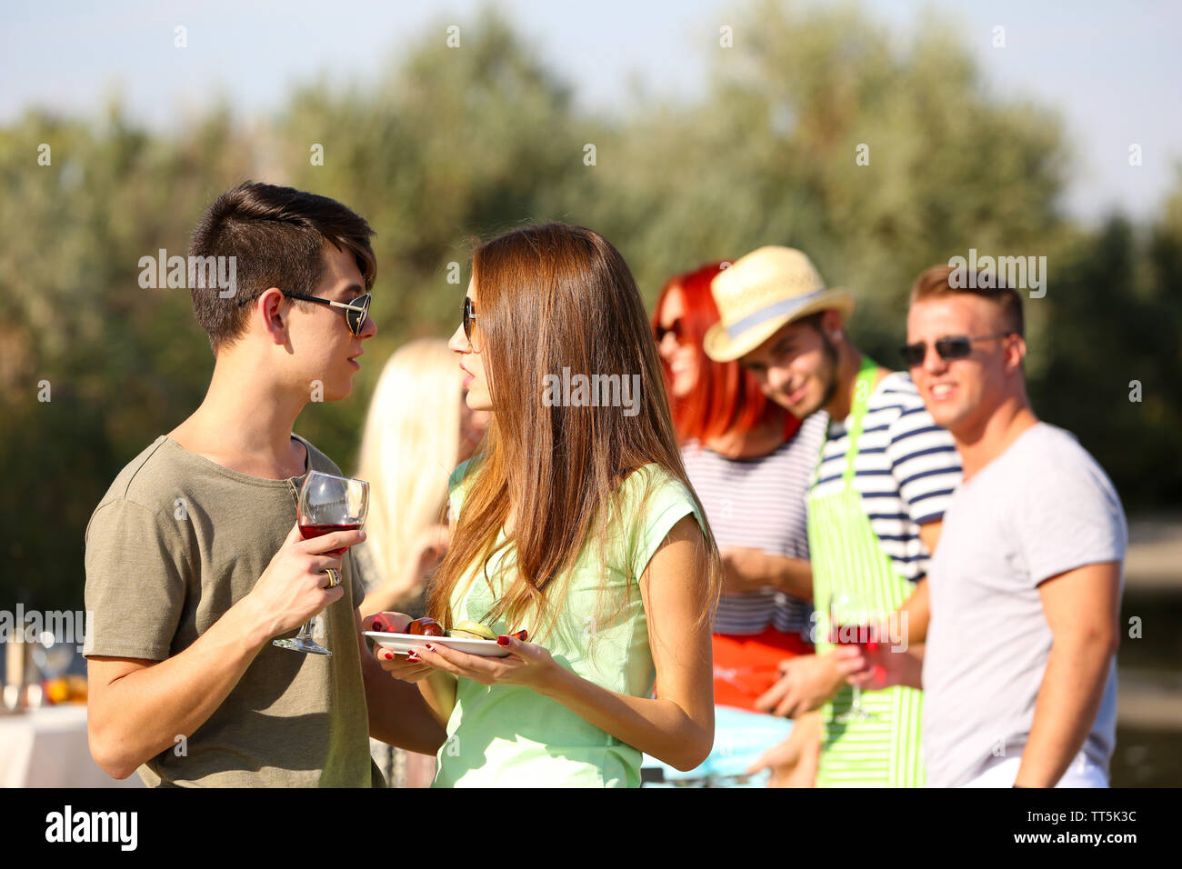 Young couple with friends on rest, outdoors Stock Photo - Alamy
