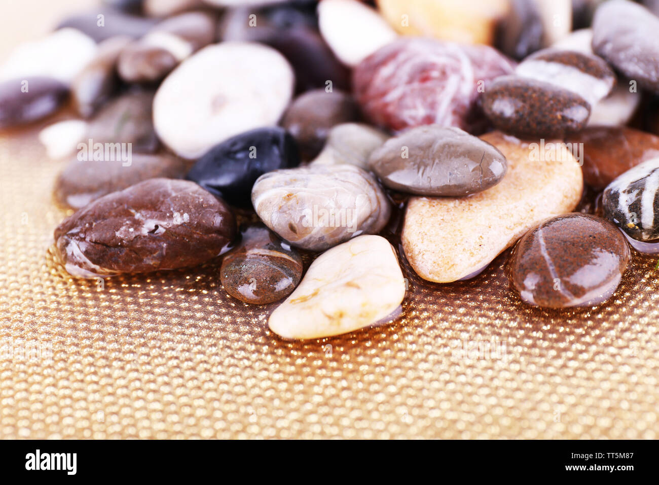 Sea stones on golden surface Stock Photo - Alamy