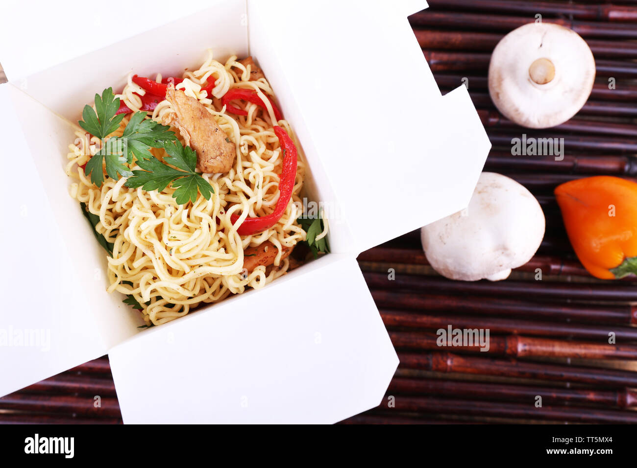 Chinese noodles in takeaway box on bamboo mat background Stock Photo ...