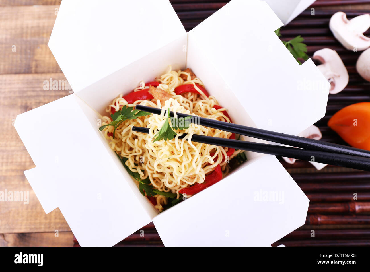 Chinese noodles in takeaway box on bamboo mat background Stock Photo ...