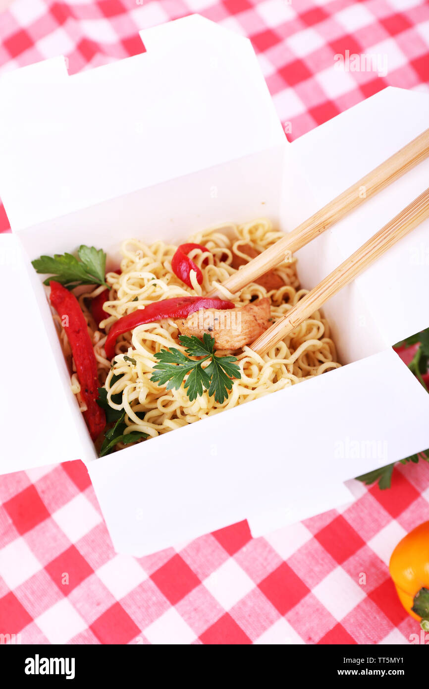 Chinese noodles and sticks in takeaway box on fabric background Stock ...