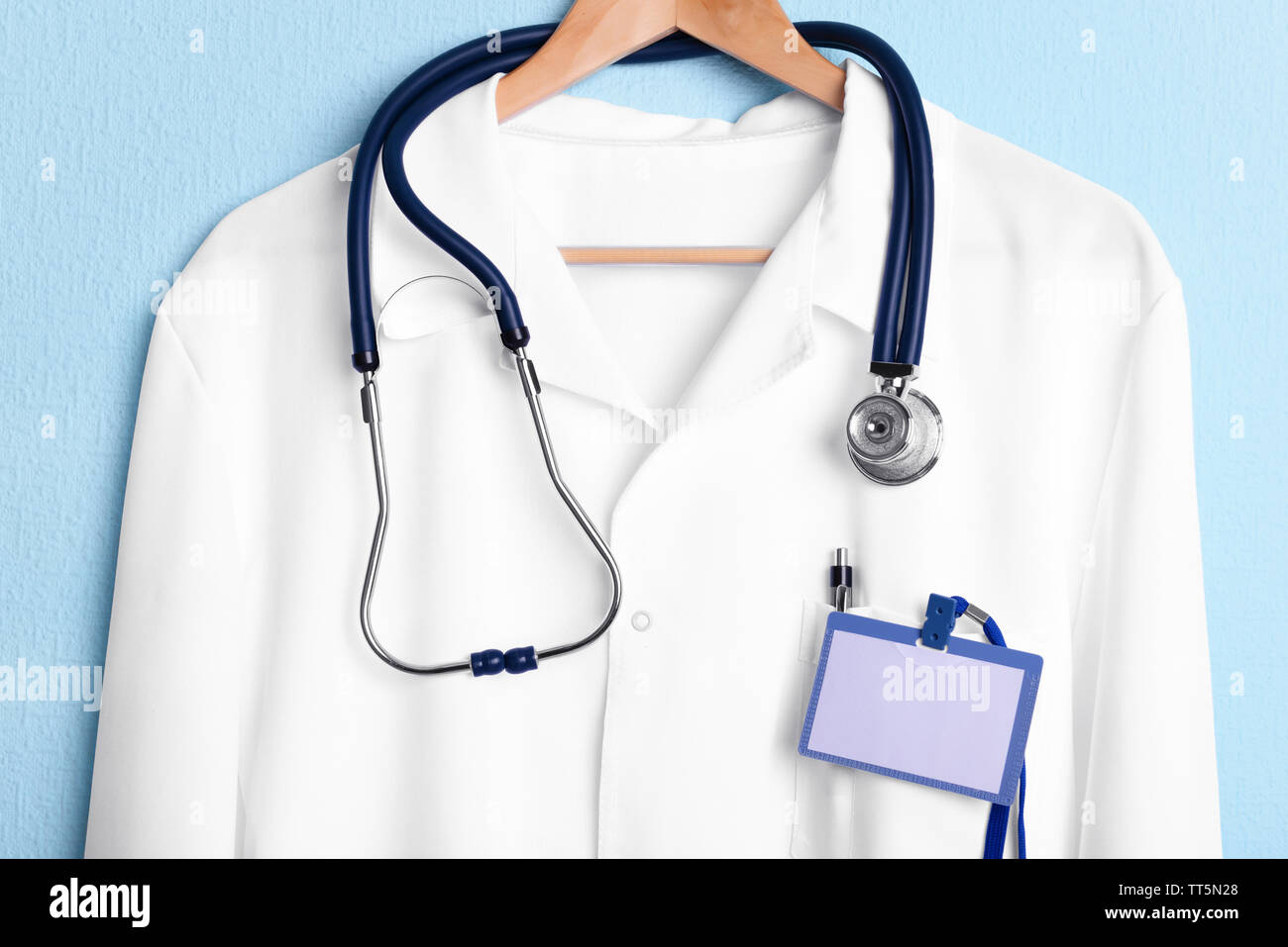 Doctor coat with stethoscope on hanger on blue background Stock Photo ...