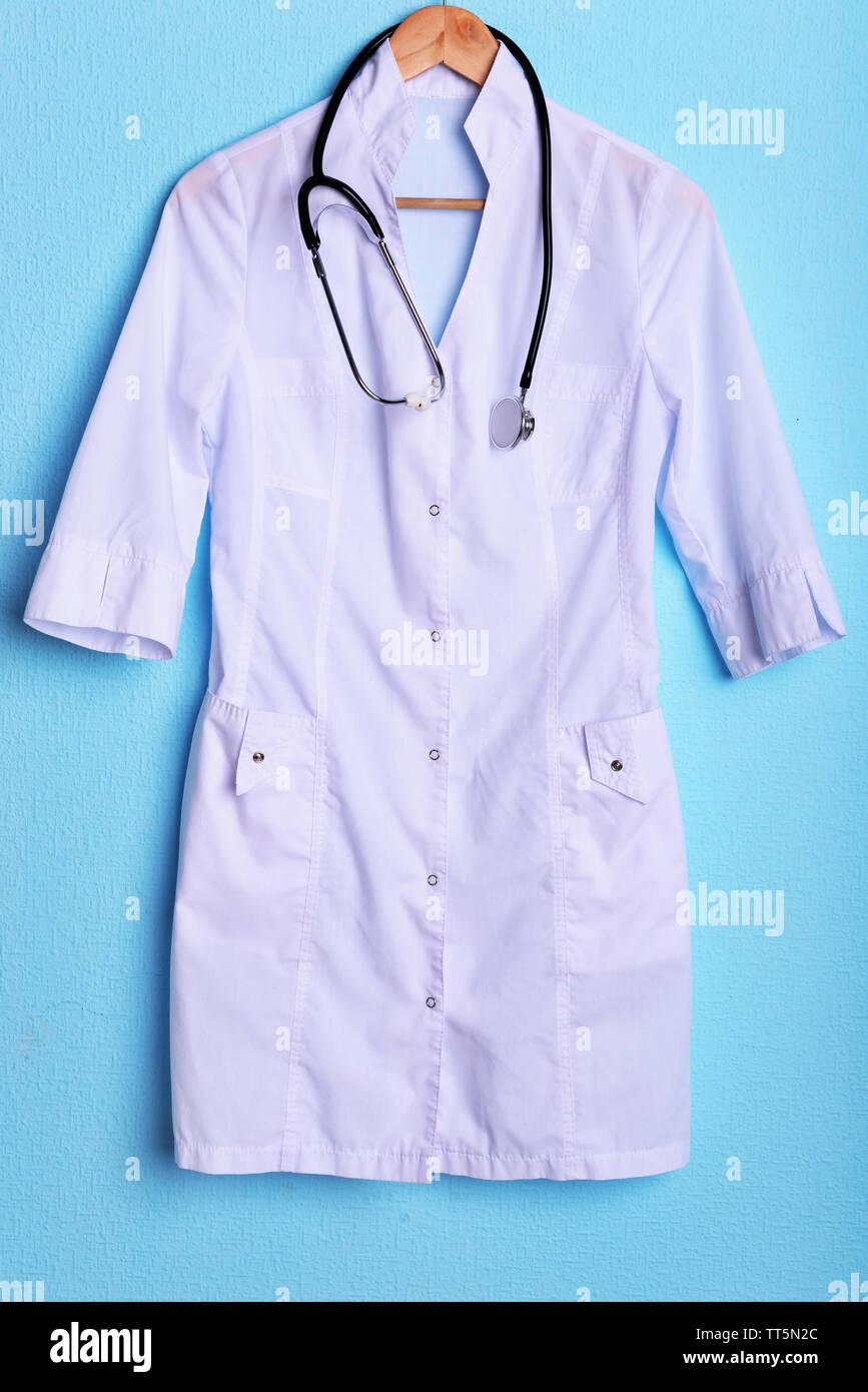 Doctor coat with stethoscope on hanger on blue background Stock Photo ...
