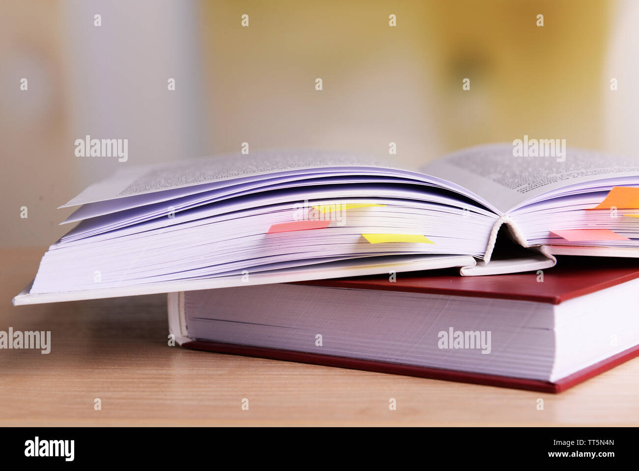 Books with bookmarks on table on bright background Stock Photo - Alamy