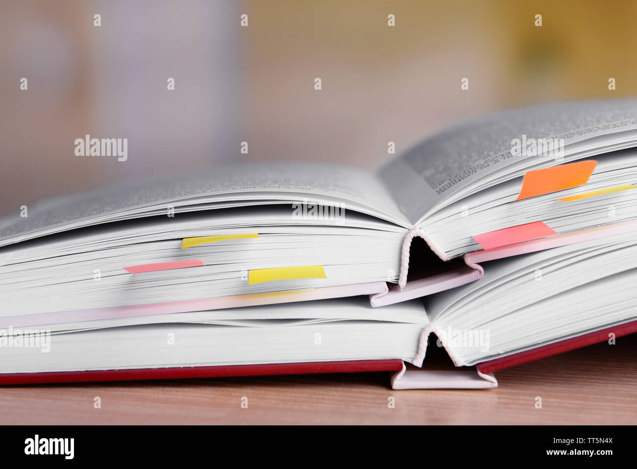 Books with bookmarks on table on bright background Stock Photo - Alamy