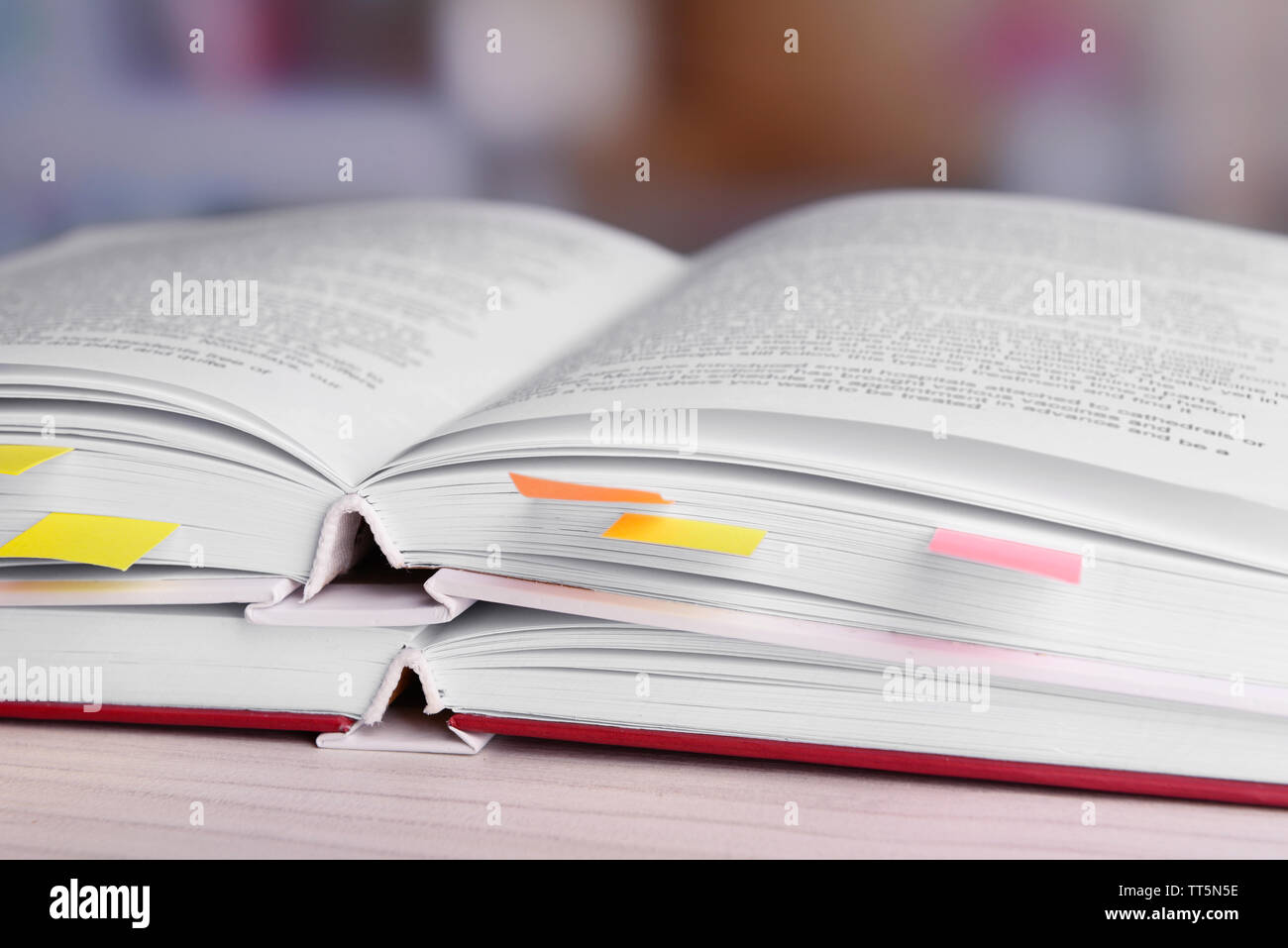 Books with bookmarks on table on bright background Stock Photo - Alamy
