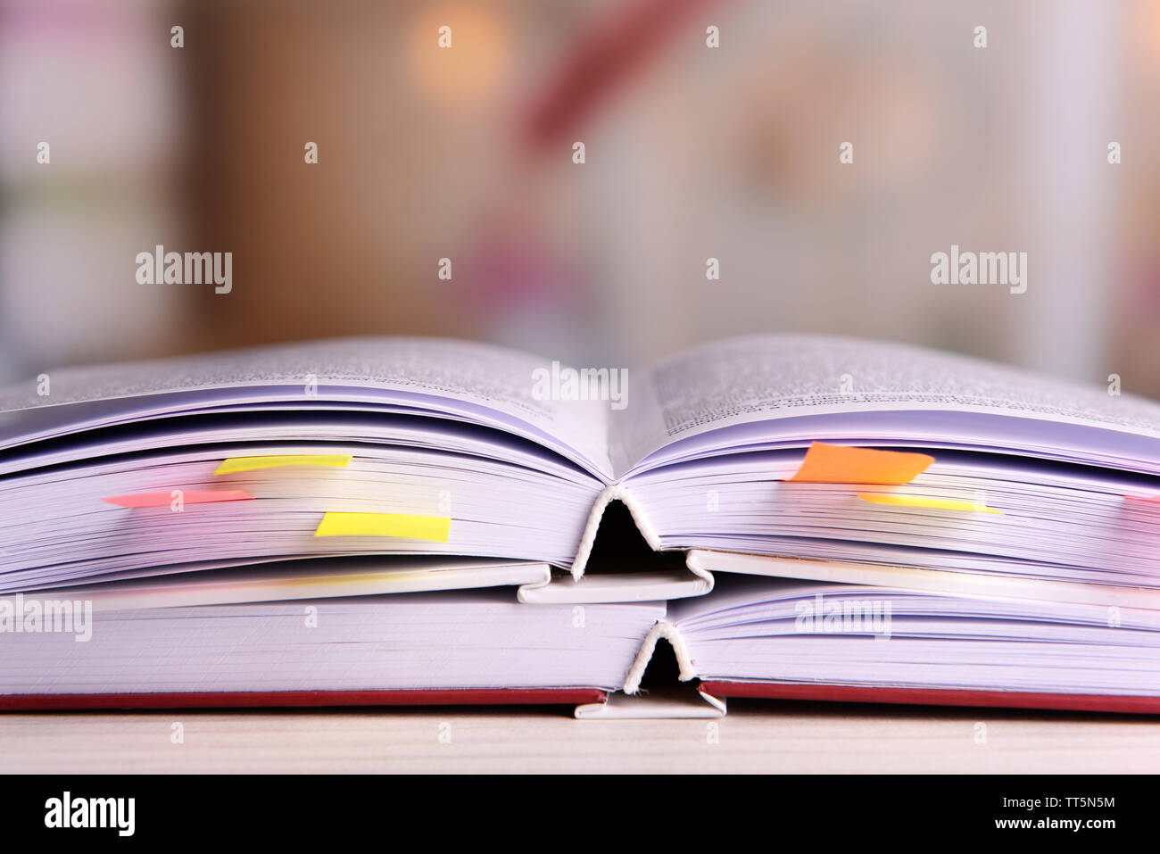 Books with bookmarks on table on bright background Stock Photo - Alamy