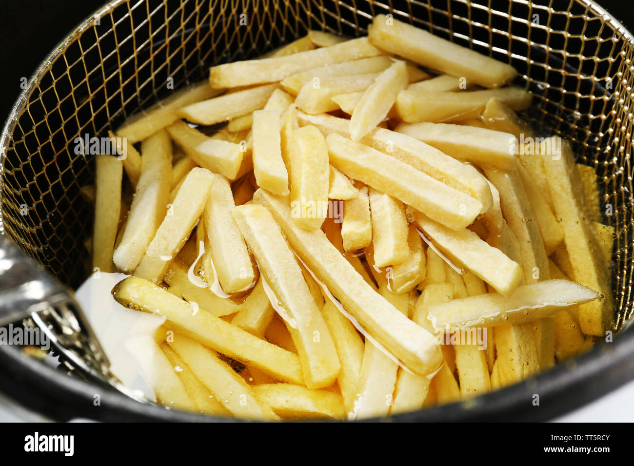 French fries in deep fryer, closeup Stock Photo - Alamy