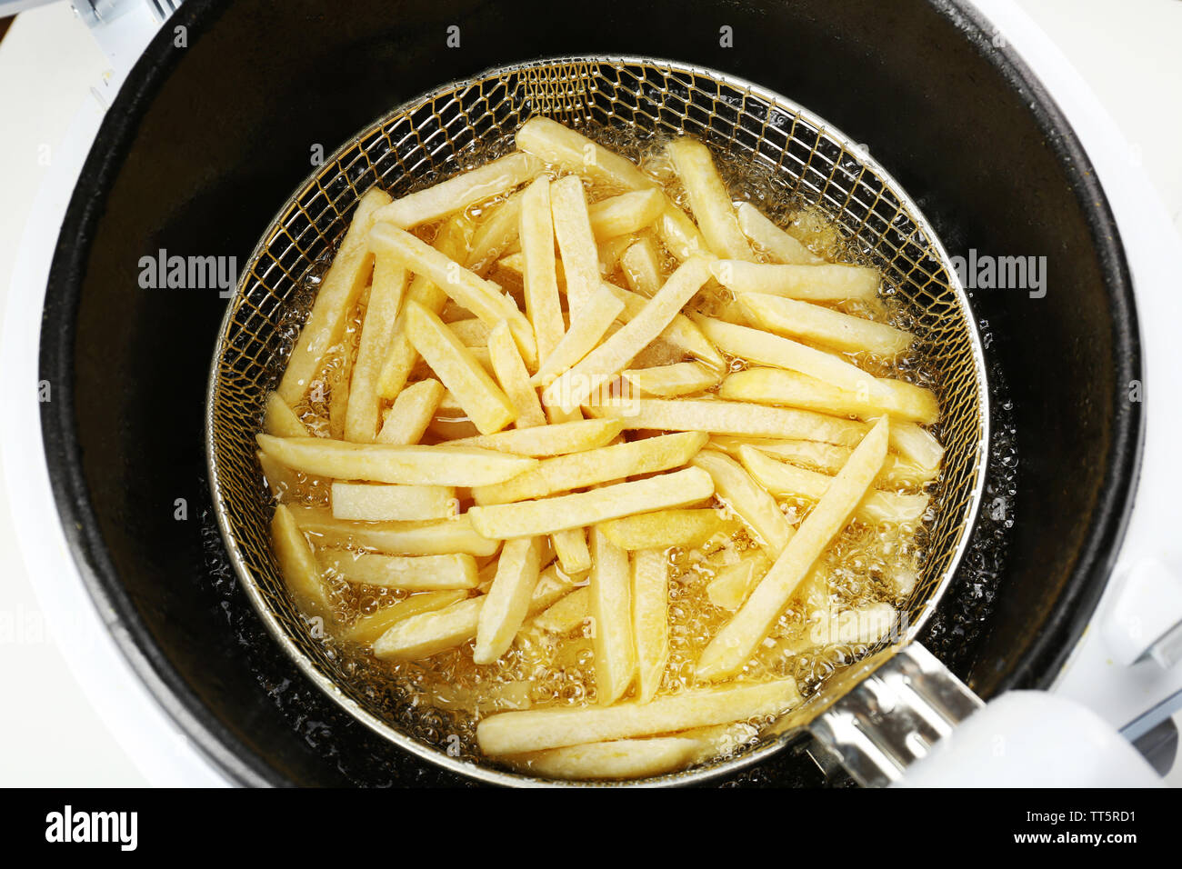 French fries in deep fryer, closeup Stock Photo - Alamy