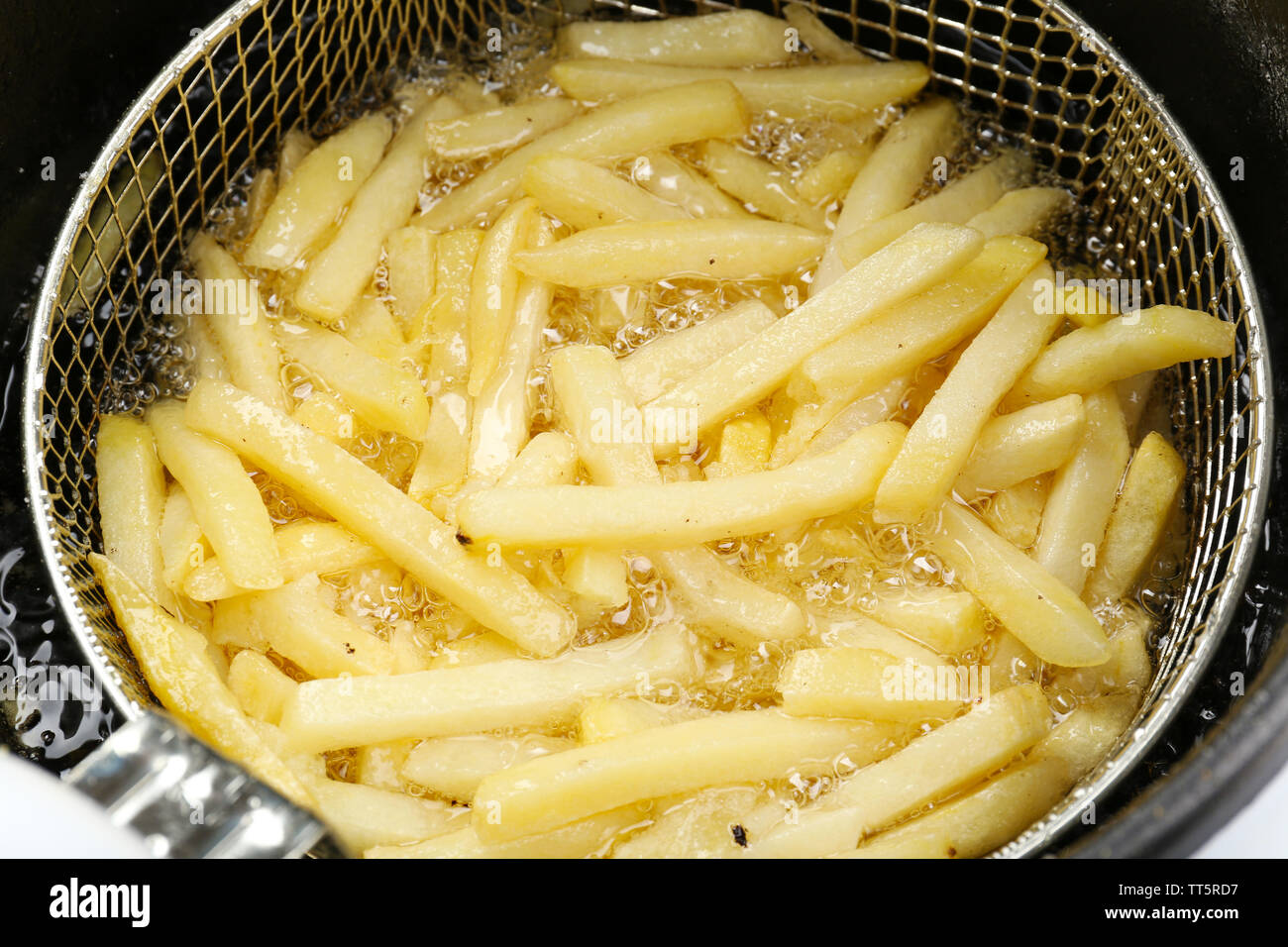 French fries in deep fryer, closeup Stock Photo - Alamy