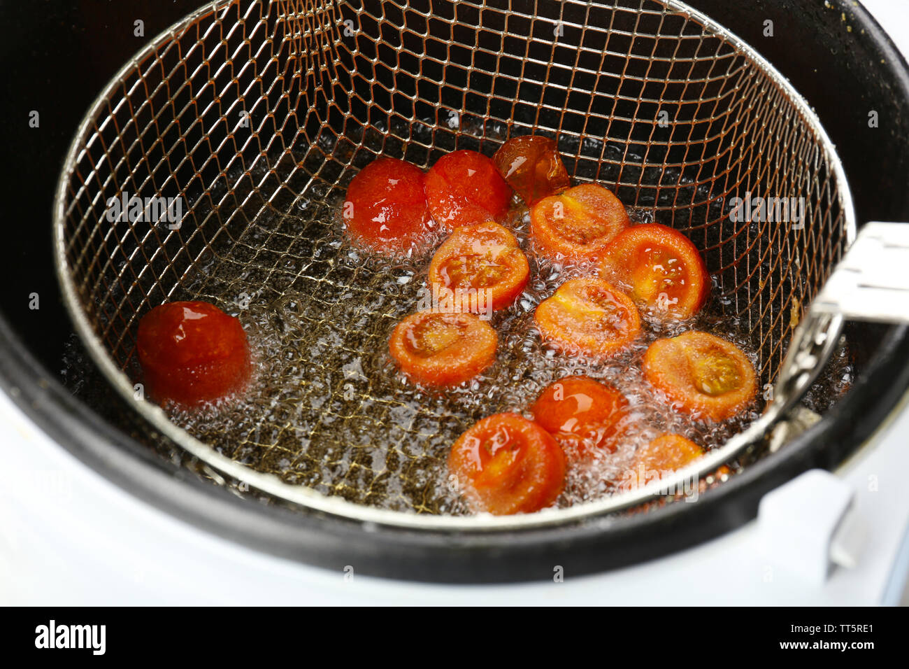 Tomato in deep fryer, closeup Stock Photo - Alamy