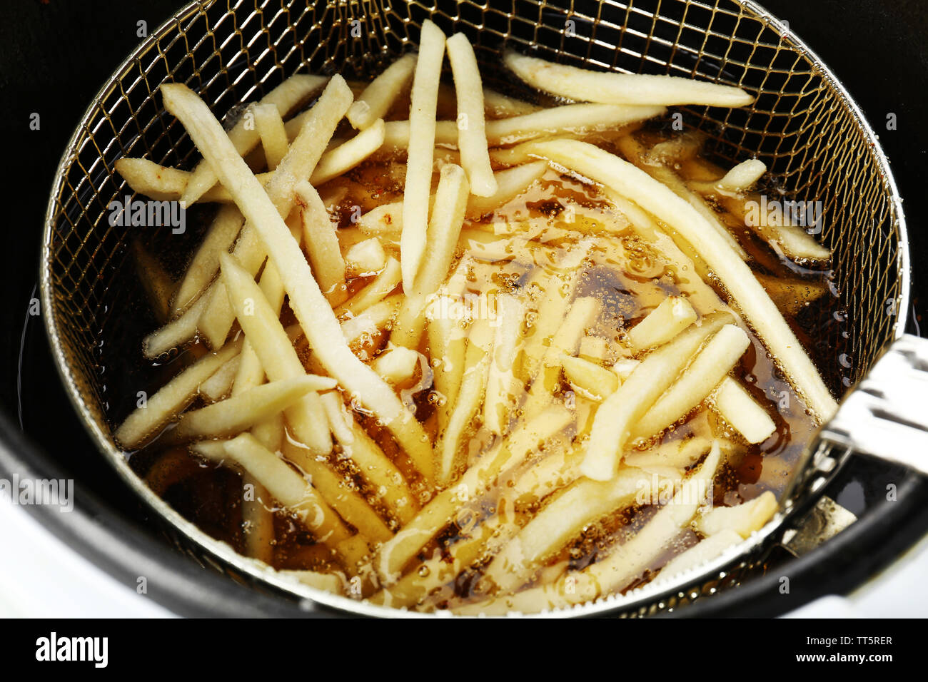 French fries in deep fryer, closeup Stock Photo - Alamy