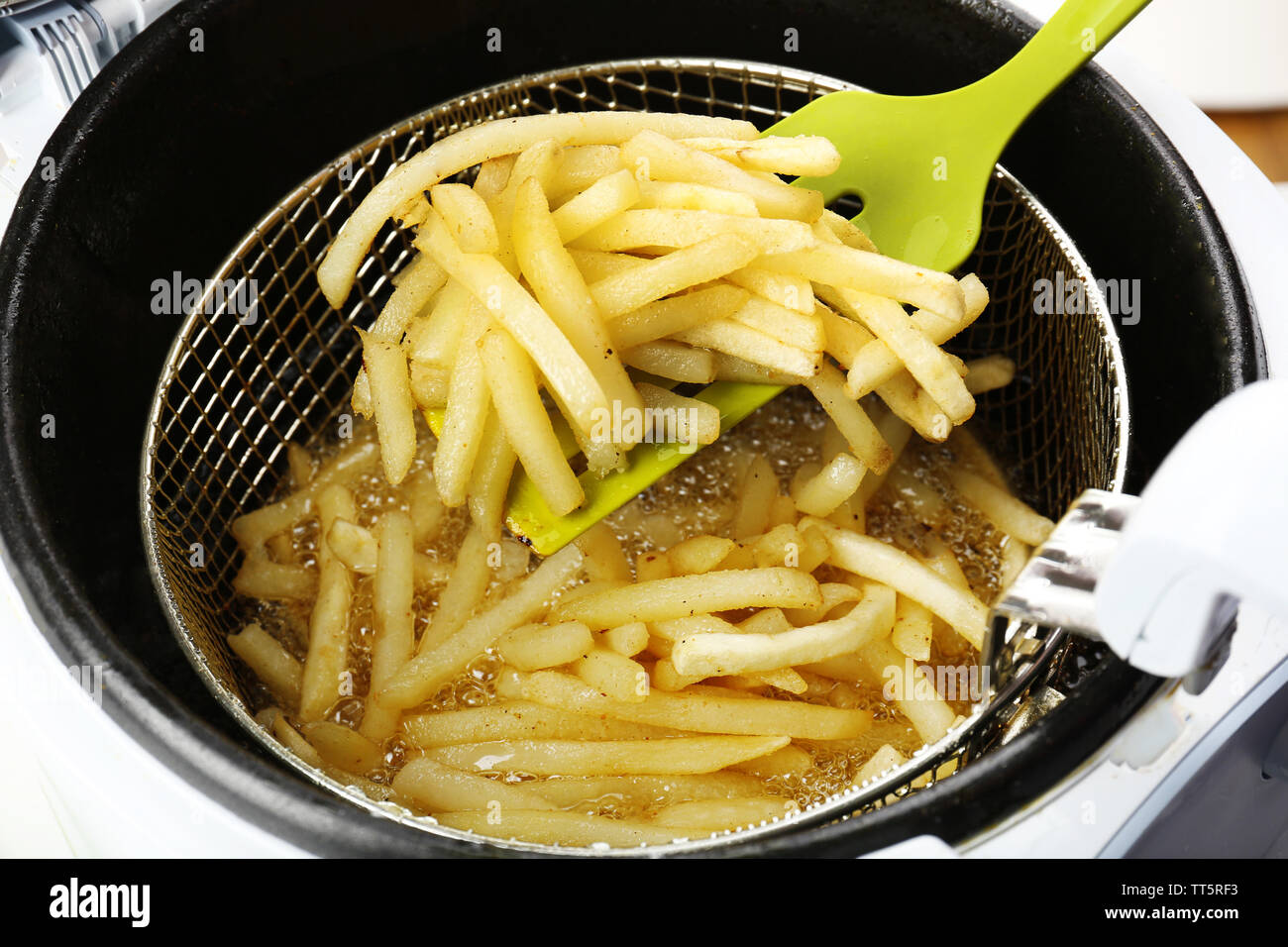 French fries in deep fryer, closeup Stock Photo - Alamy