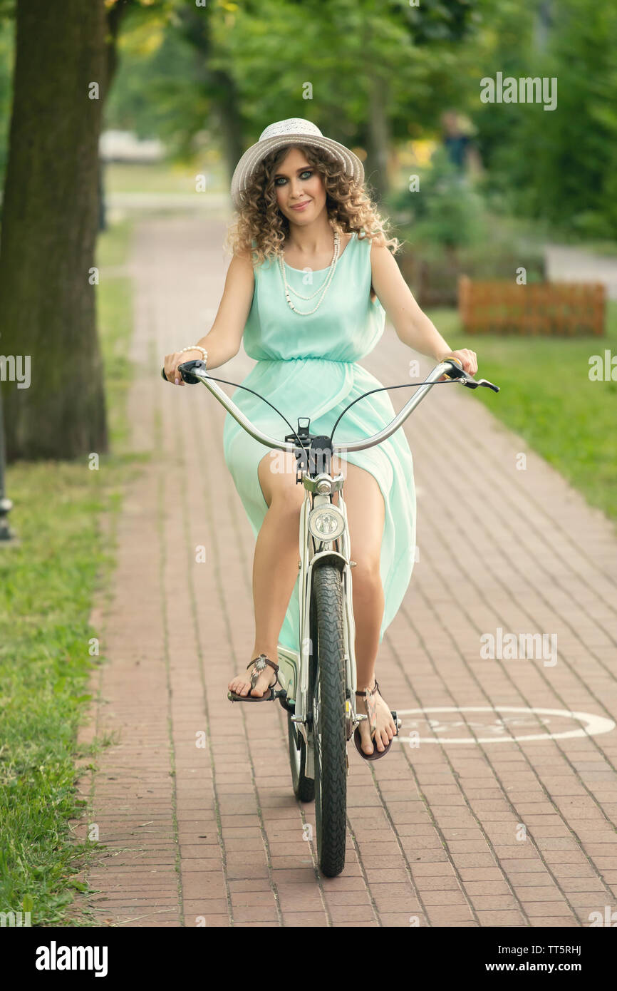 pretty woman biker on bicycle riding on street smiling Stock Photo - Alamy