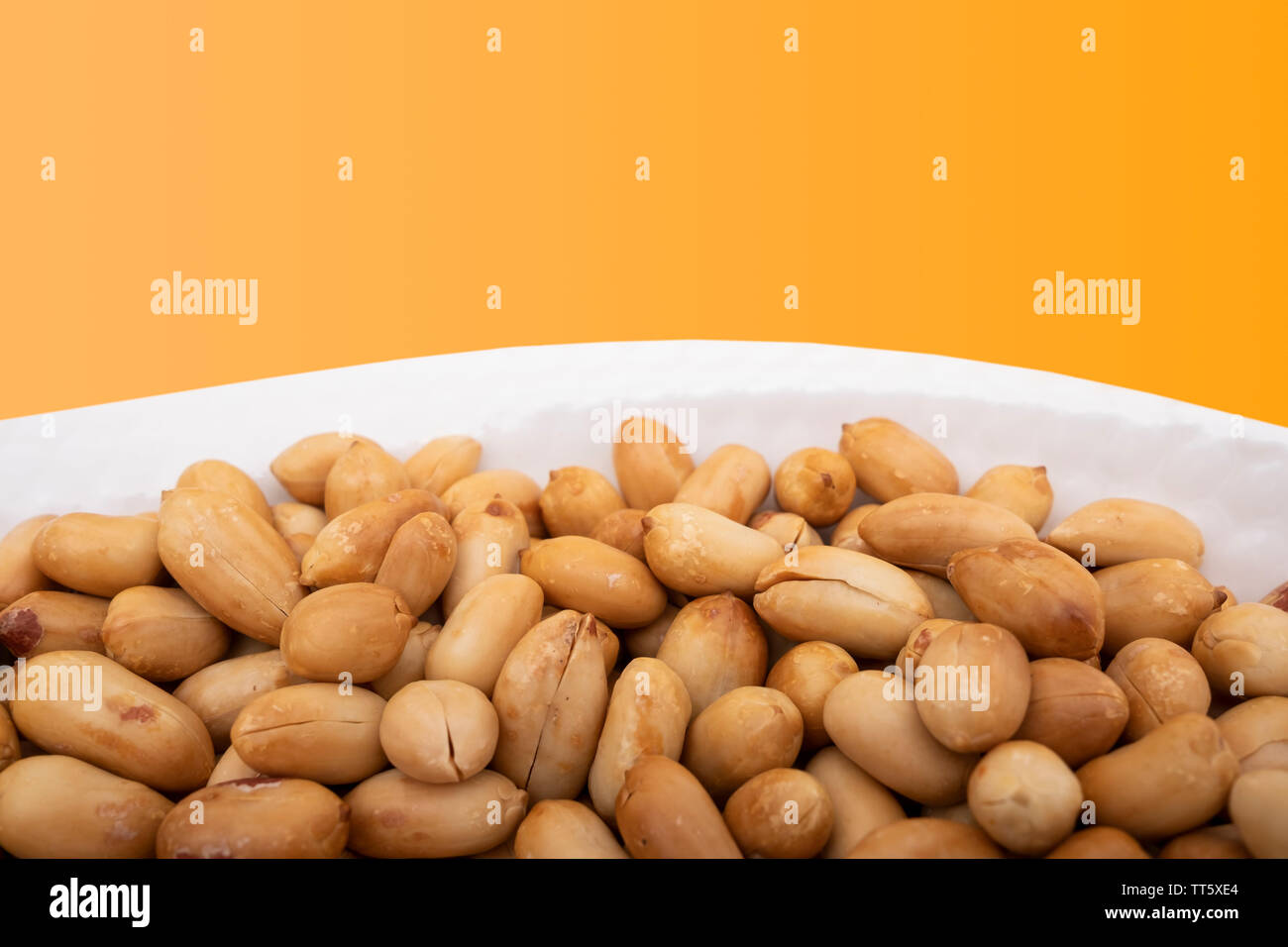 Roasted peanuts on isoalted yellow background Stock Photo - Alamy