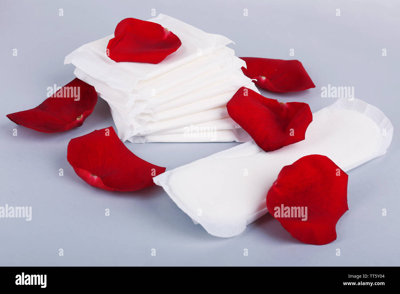 Sanitary pads and rose petals on light background Stock Photo - Alamy