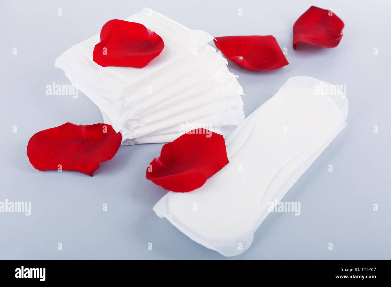 Sanitary pads and rose petals on light background Stock Photo - Alamy