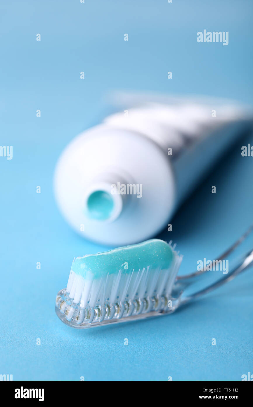 Toothbrush with blue toothpaste on color background Stock Photo - Alamy