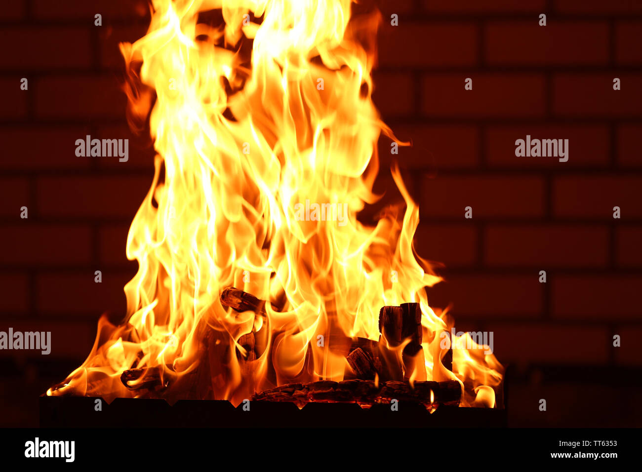 Bonfire at night on brick wall background Stock Photo - Alamy