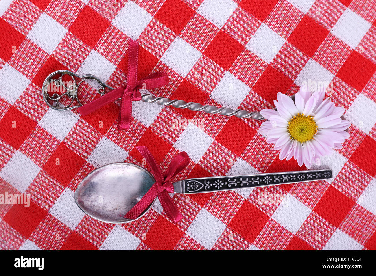 Metal spoons on checkered fabric background Stock Photo - Alamy