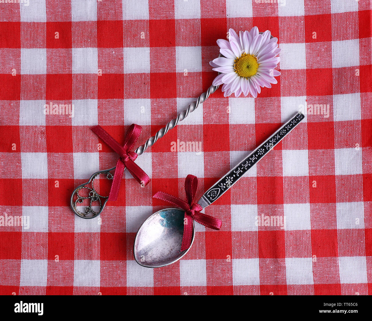 Metal spoons on checkered napkin on light blue background Stock Photo ...