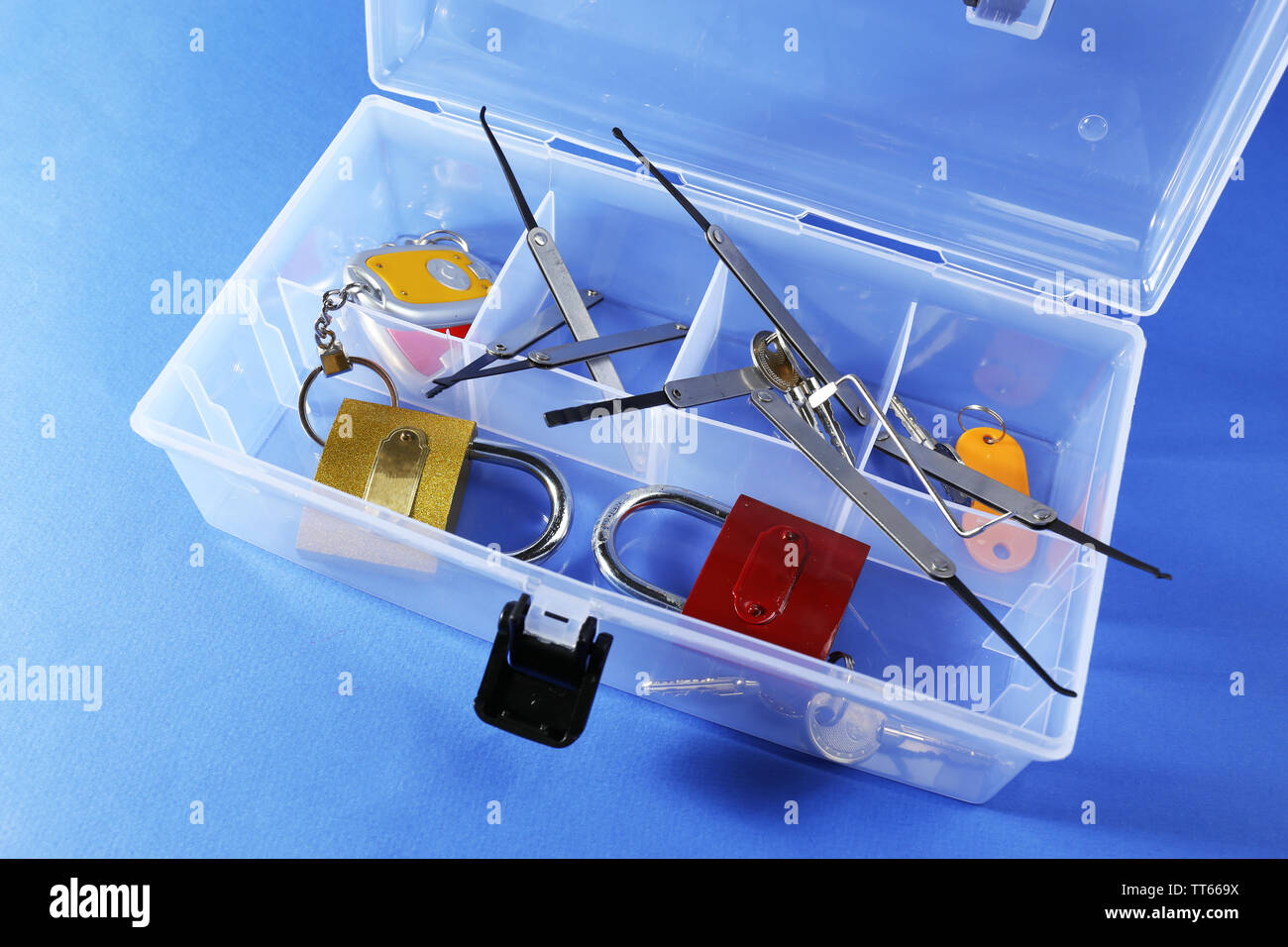 Set of keys, lock picks in box on blue background Stock Photo - Alamy