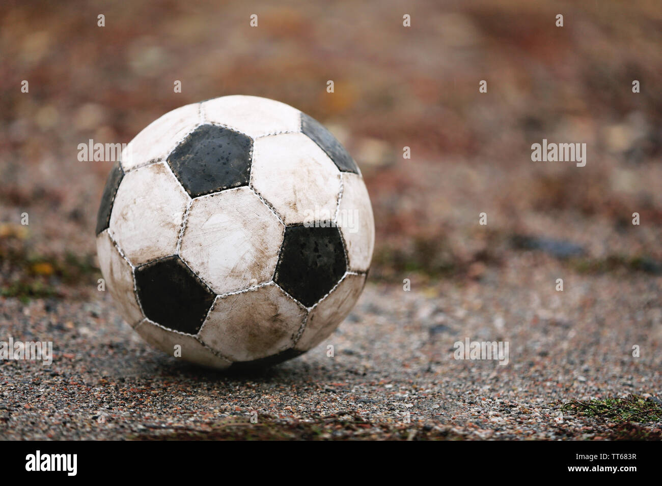 Soccer ball on ground in rainy day, outdoors Stock Photo - Alamy
